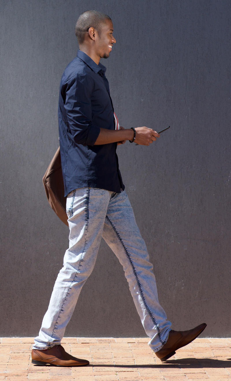 black male student walking with tablet - Sequence Wiz